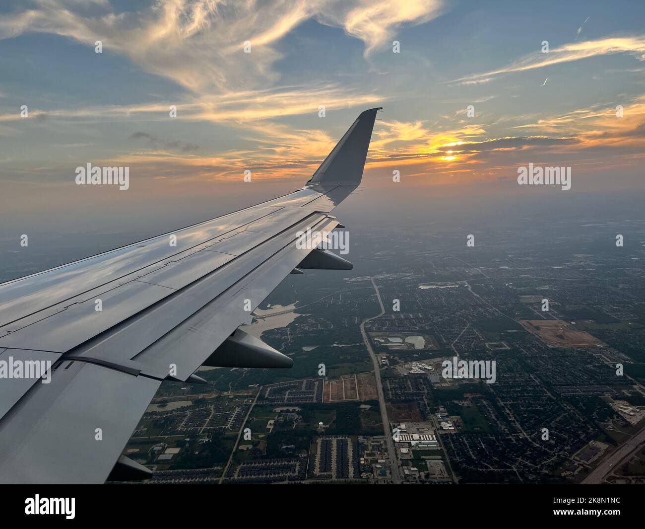 The wing of a commercial airline airplane while flying high in the sky ...