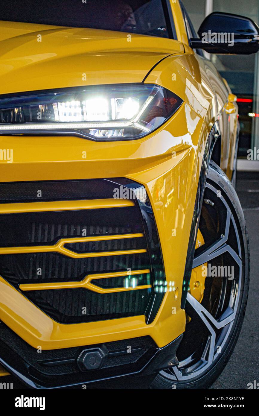 The vertical partial view of a yellow Lamborghini Urus with the front ...