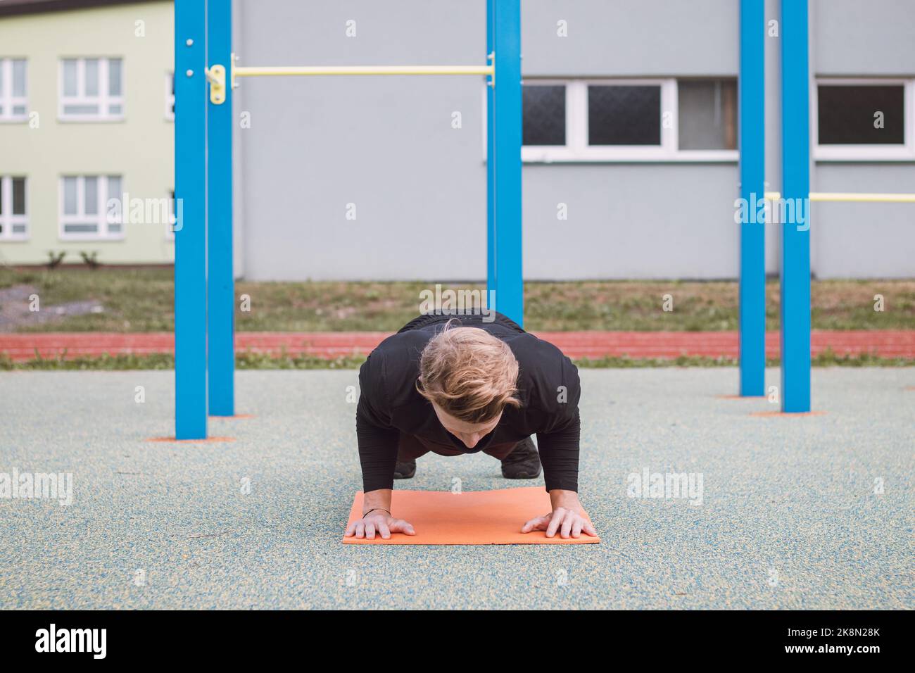 Blonde athlete performs an exercise called a push-up. A heavy intense ...