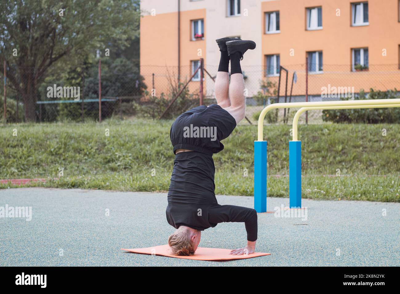 Calisthenics athlete performs a headstand using a solid core and arm ...