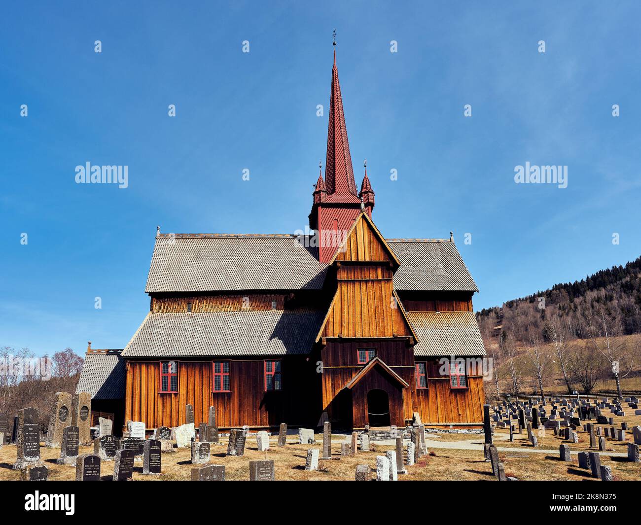 The old wooden Ringebu Stave Church with a graveyard and hills in the ...