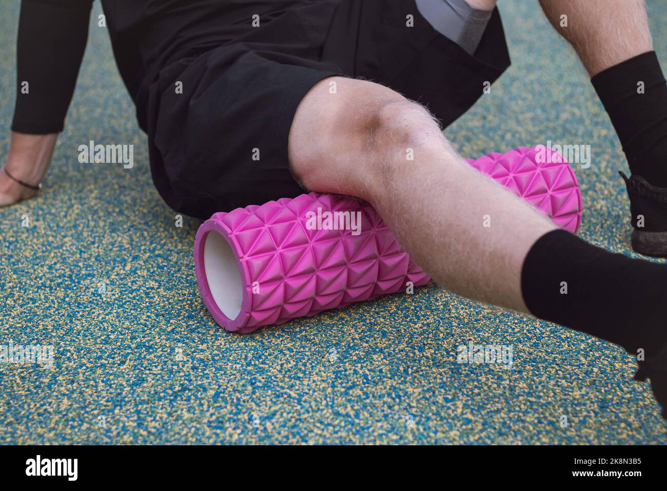Fitness Trainer Exercises And Warms Up The Lower Part Of The Body With The Help Of A Massage