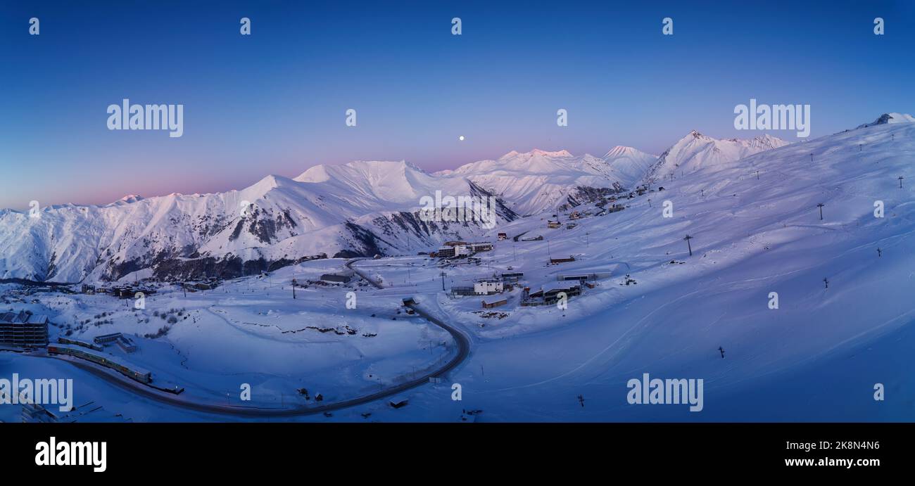 Wide aerial panorama of snowy mountain ridge on winter sunrise ...
