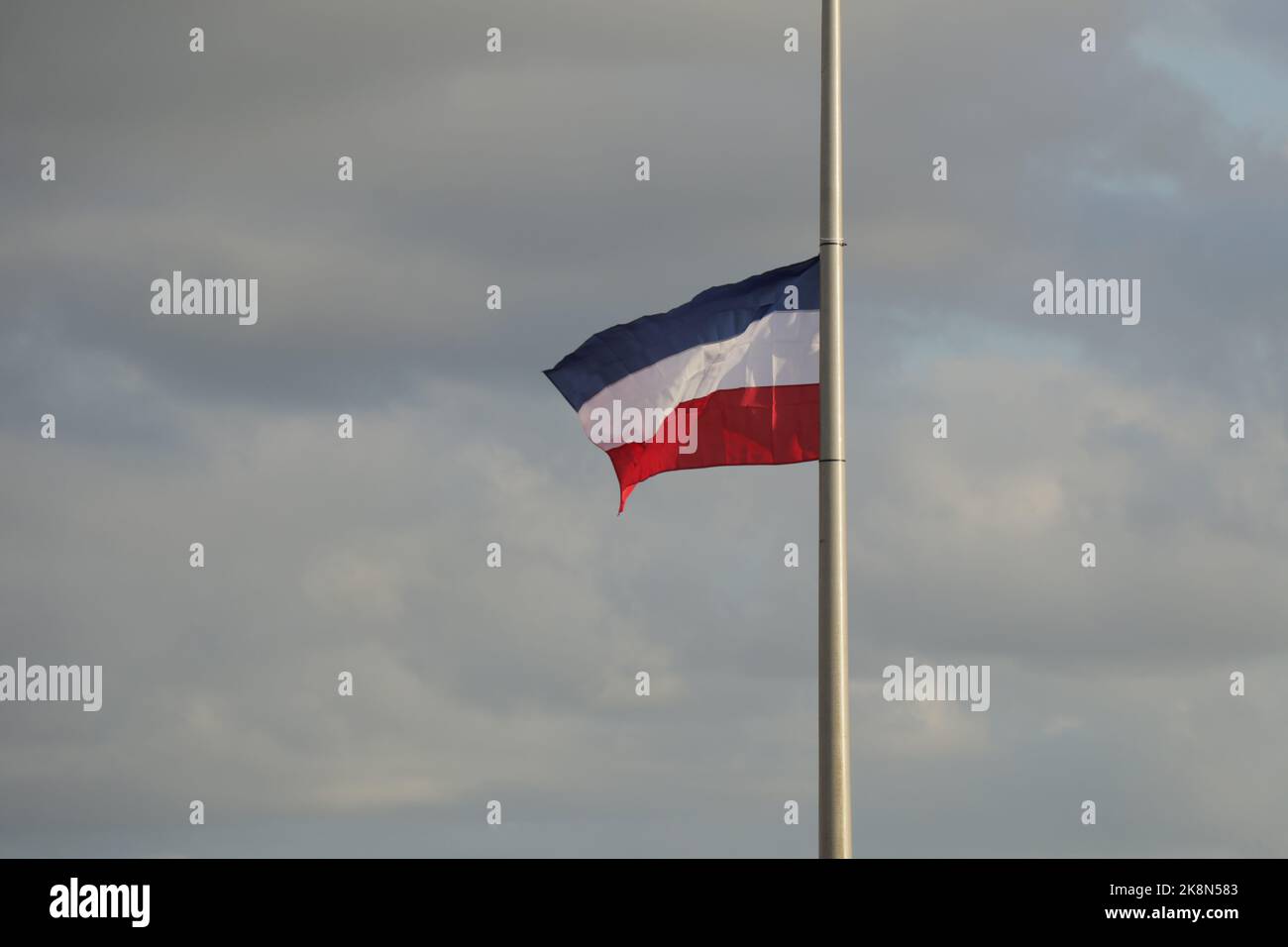 Upside-down Dutch flag hanging on lamp post against a cloudy sky Stock ...