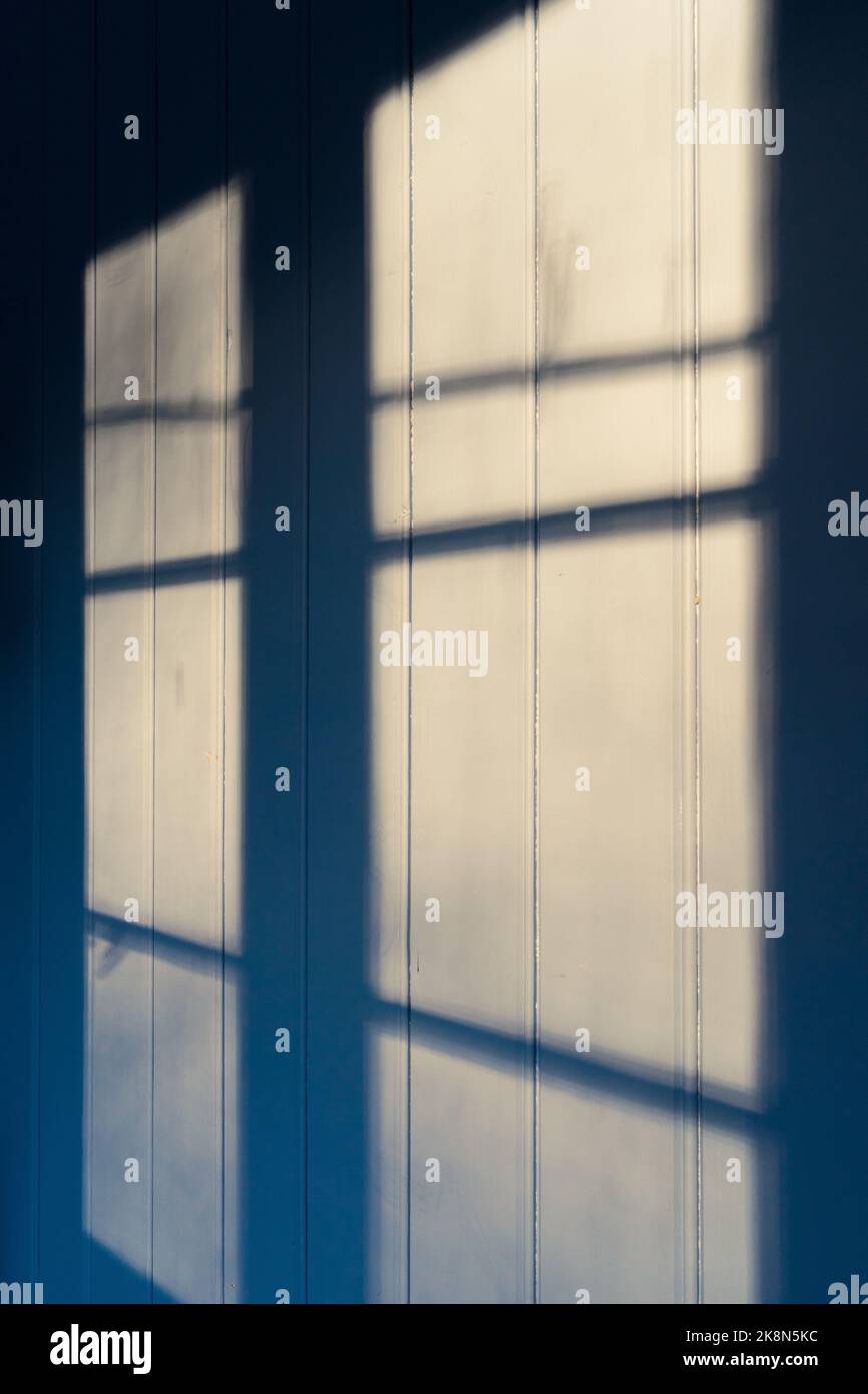evening light from a window hits a blue wall of wood paneling Stock ...
