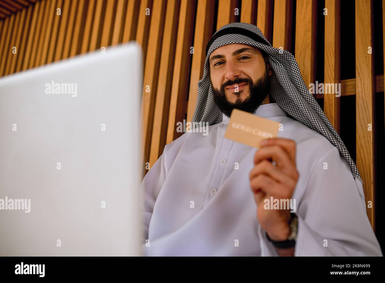 An arabian man in traditional clothing holding a credit card Stock ...