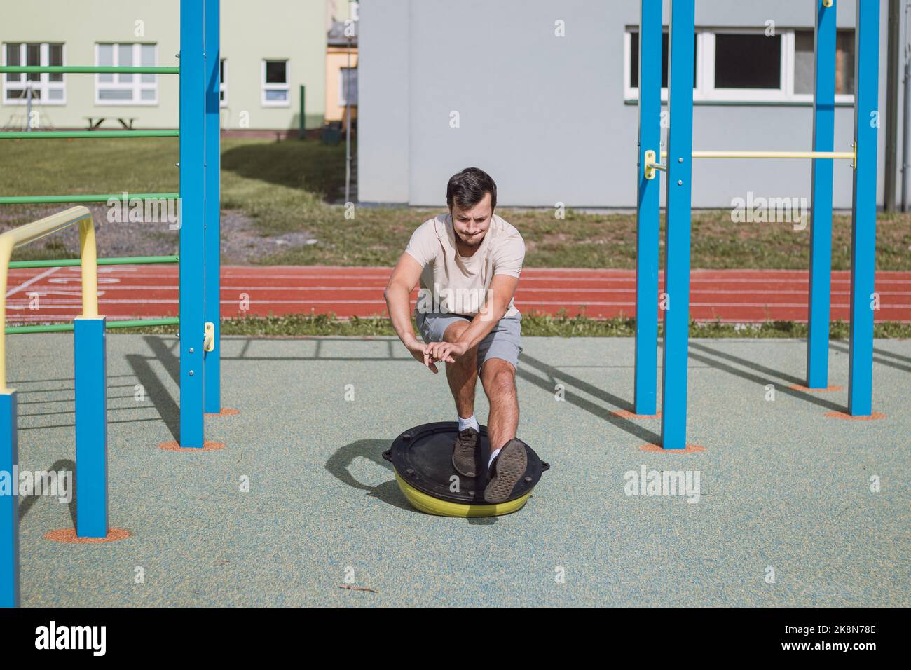 Brown-haired professional athlete does a one-legged squat on a balance ...