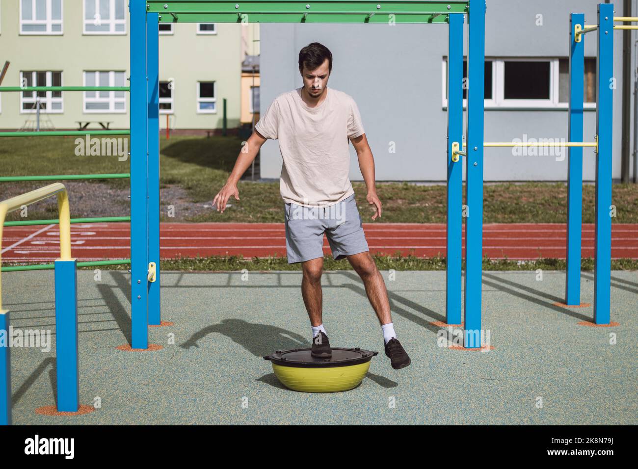 Brown-haired professional athlete does a one-legged squat on a balance ...