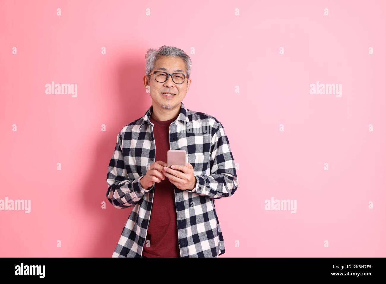 The 40s adult Asian man stnading on the pink background with casual ...