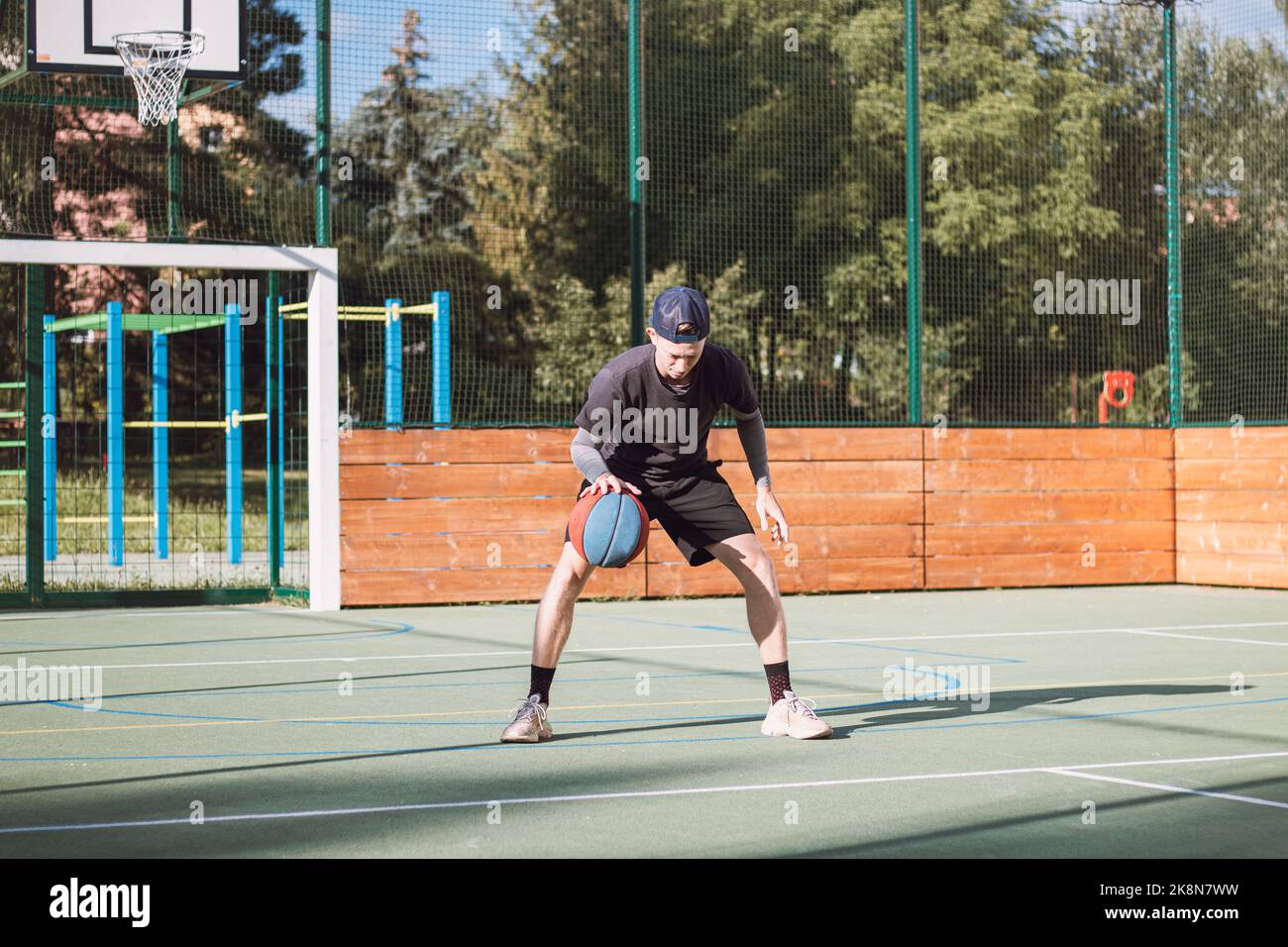 Basketball player bouncing dribbling between hi-res stock photography ...