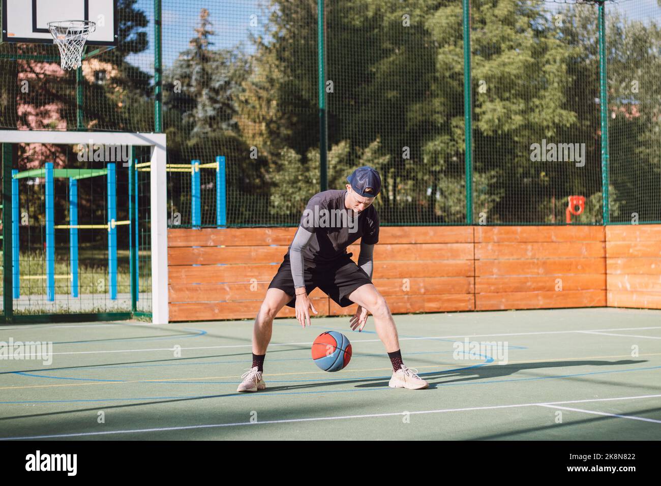 Young talent practices dribbling the basketball under his feet and ...