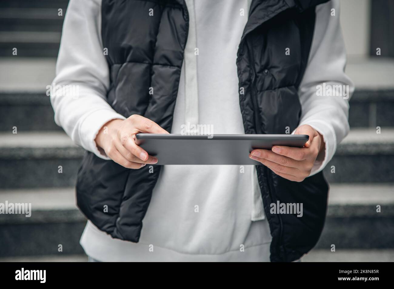 Close-up, a woman is using a tablet outside Stock Photo - Alamy