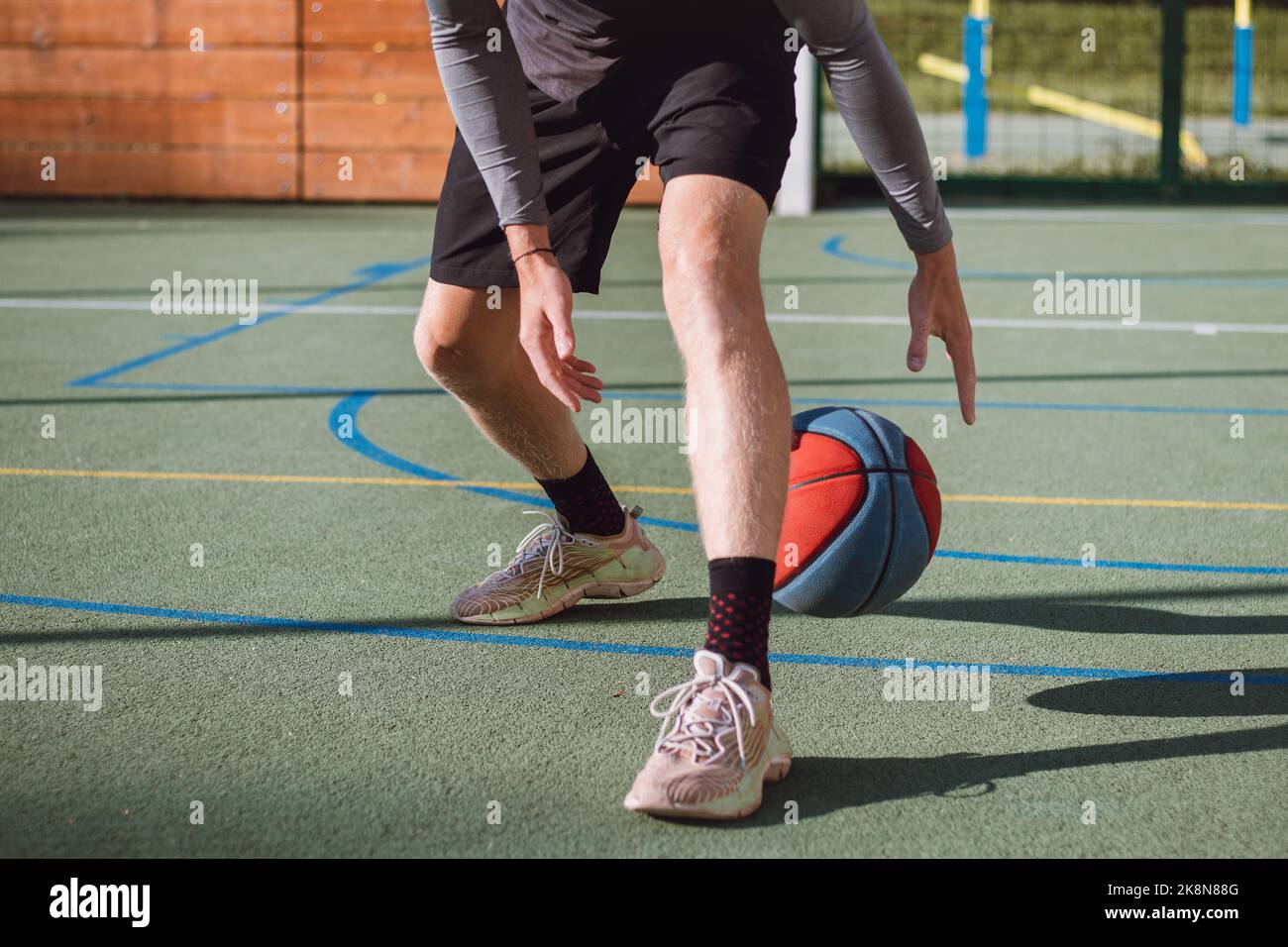 Young talent practices dribbling the basketball under his feet and ...