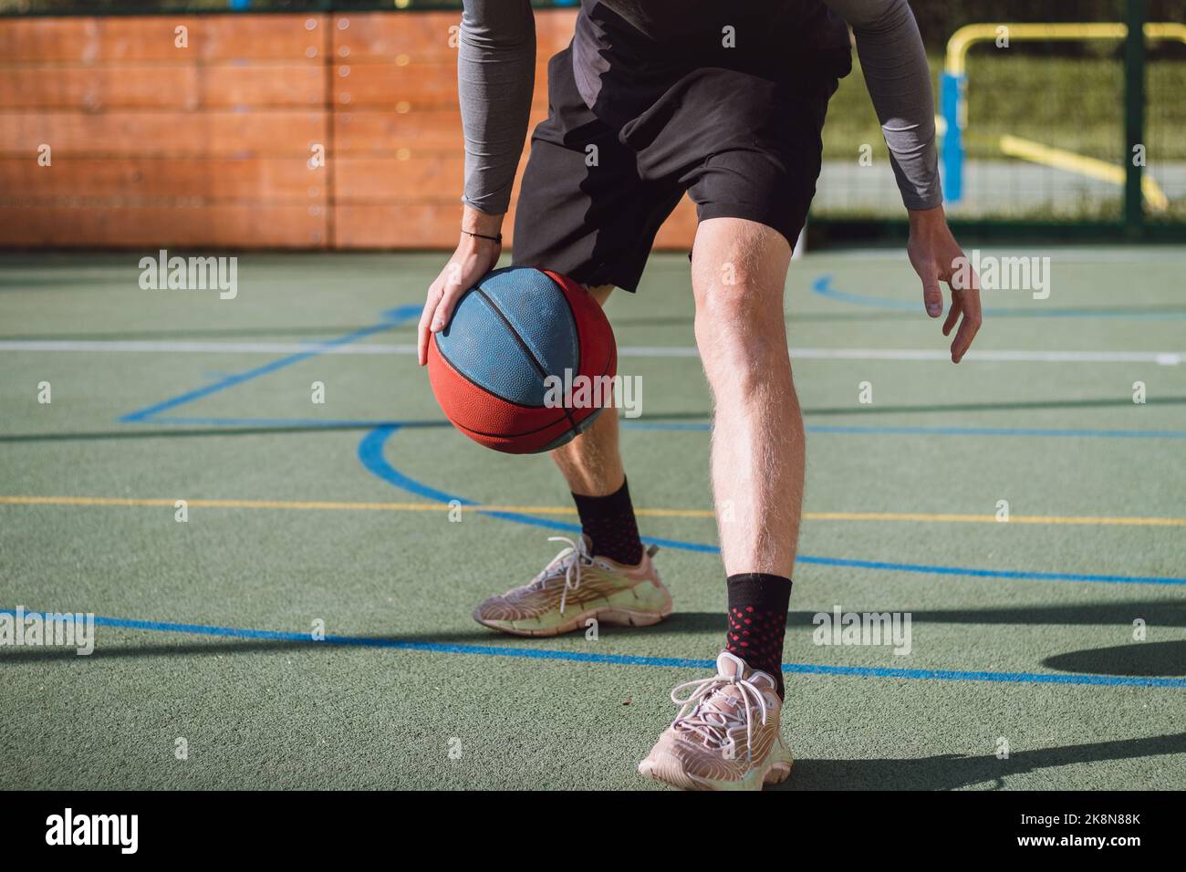 Basketball player bouncing dribbling between hi-res stock photography ...