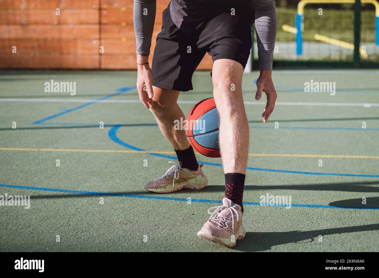 Young talent practices dribbling the basketball under his feet and ...