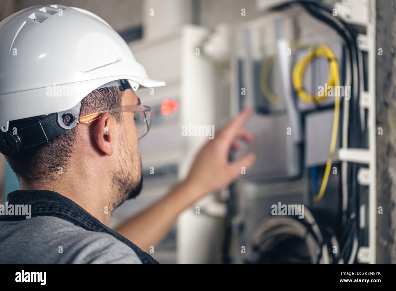 Man, an electrical technician working in a switchboard with fuses Stock ...