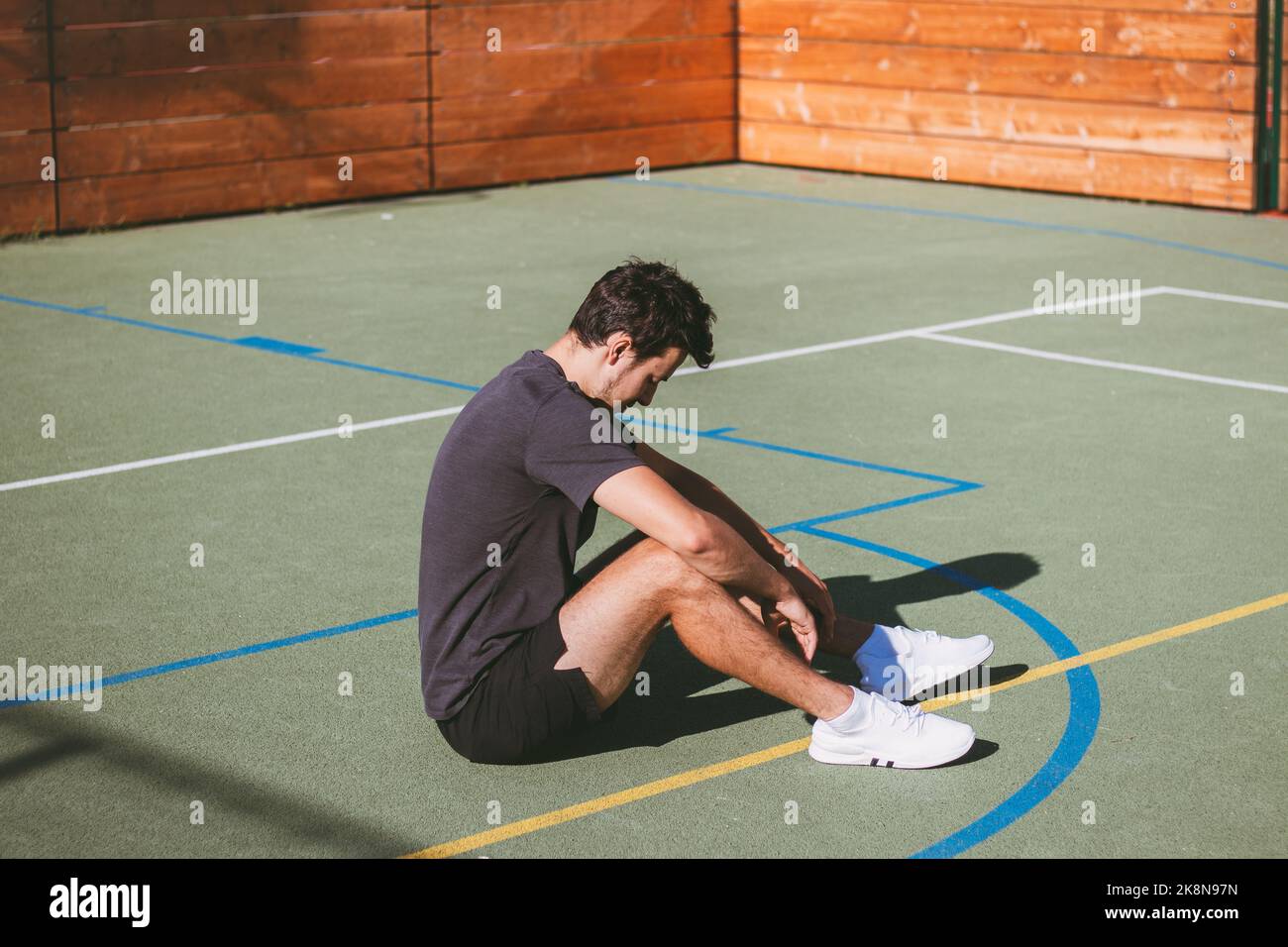 Black-haired athlete is resting heavily after a hard workout in the ...