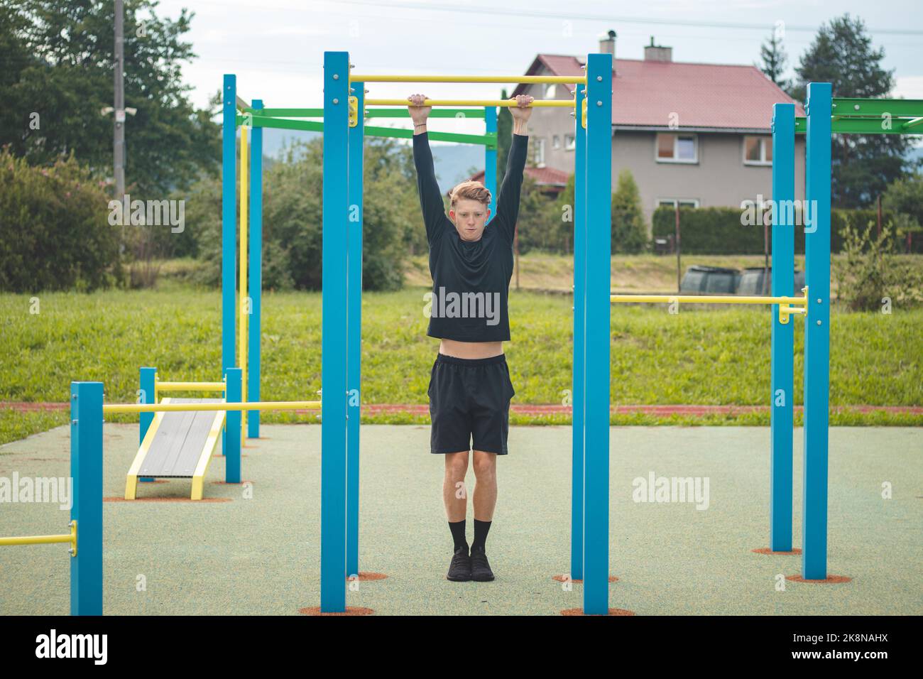 Goal-oriented blond boy builds the strength of his own body on the ...