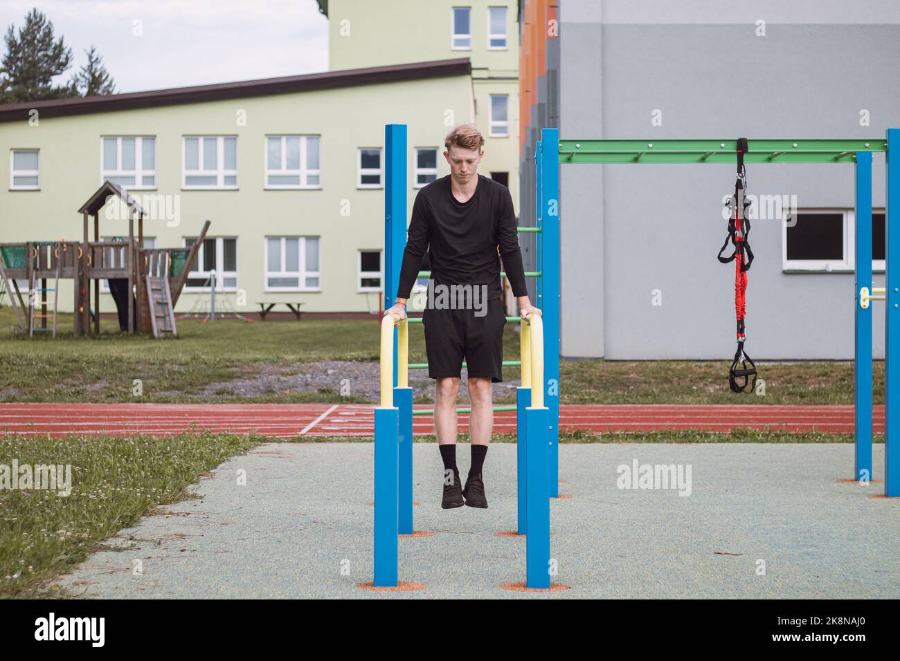 Goal-oriented blond boy builds the strength of his own body on the ...