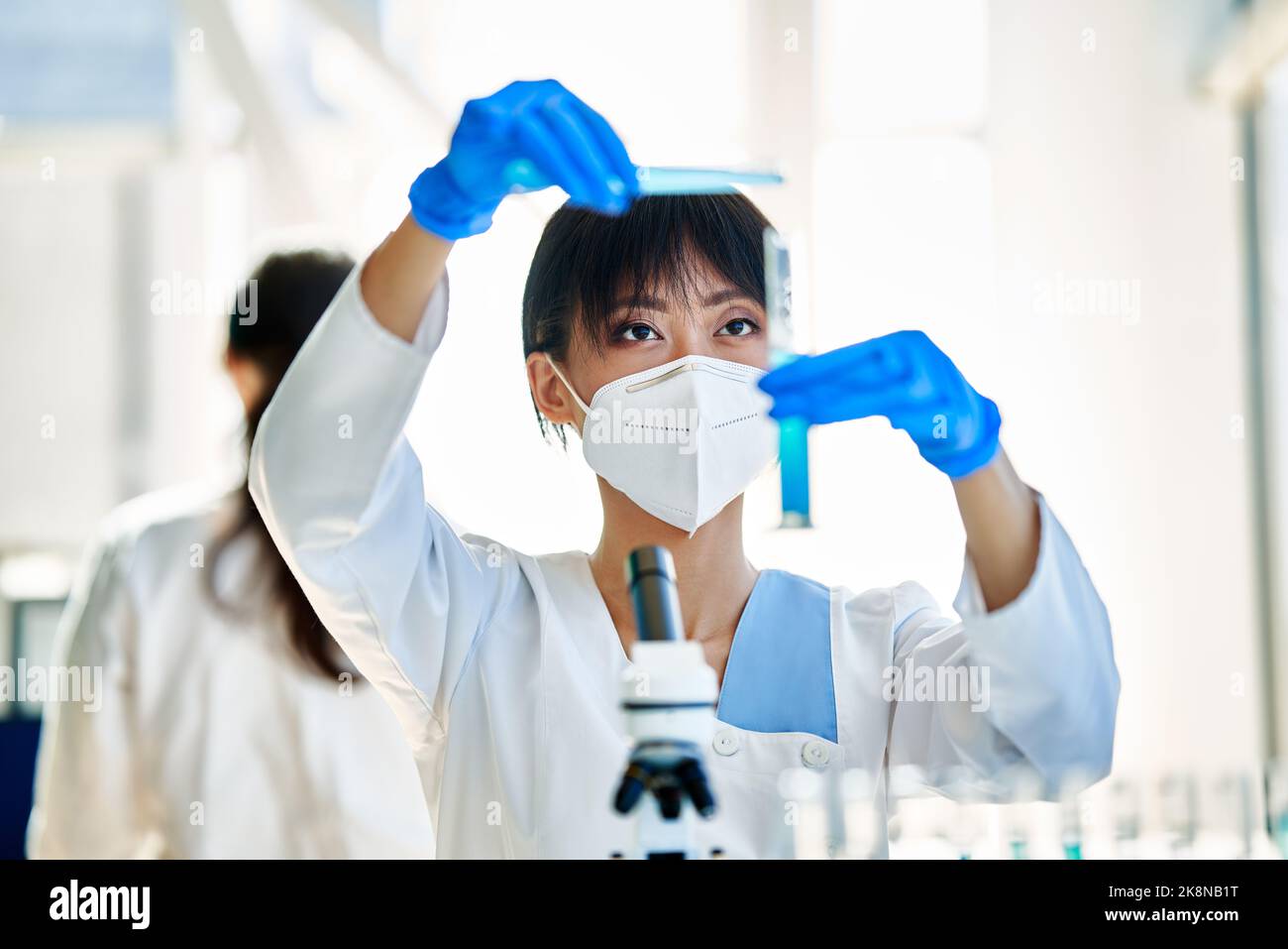 Female scientist making research pouring reagent into test tubes ...