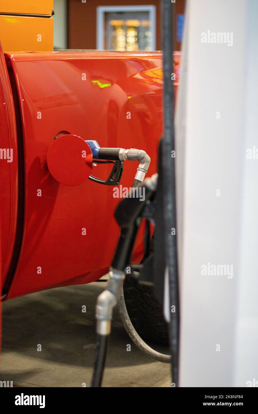 A vertical of a truck filling up at the pump parked in a gas station ...