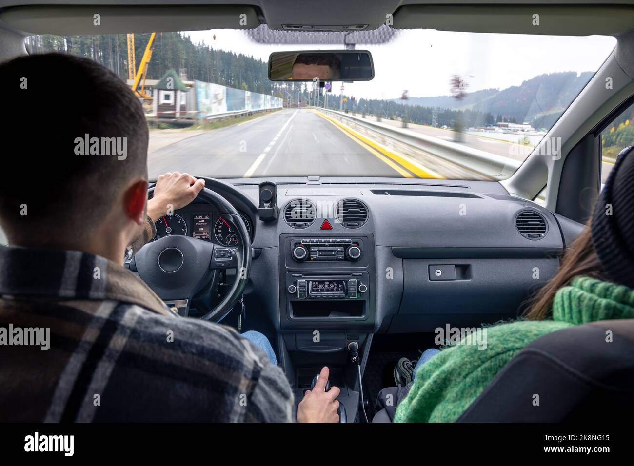 Rear back view from passenger seat of man and lady sitting inside car ...
