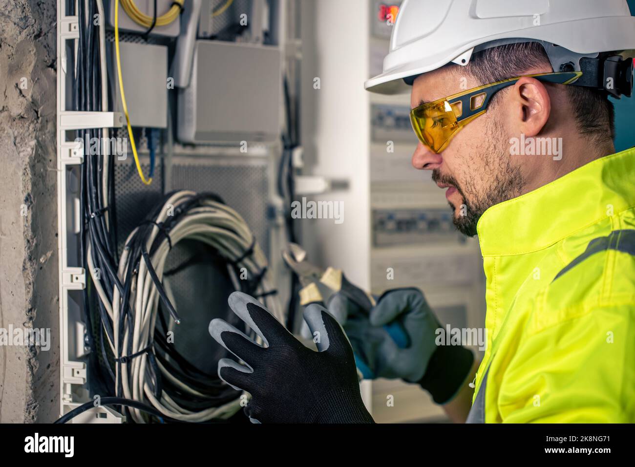 Man, an electrical technician working in a switchboard with fuses Stock ...