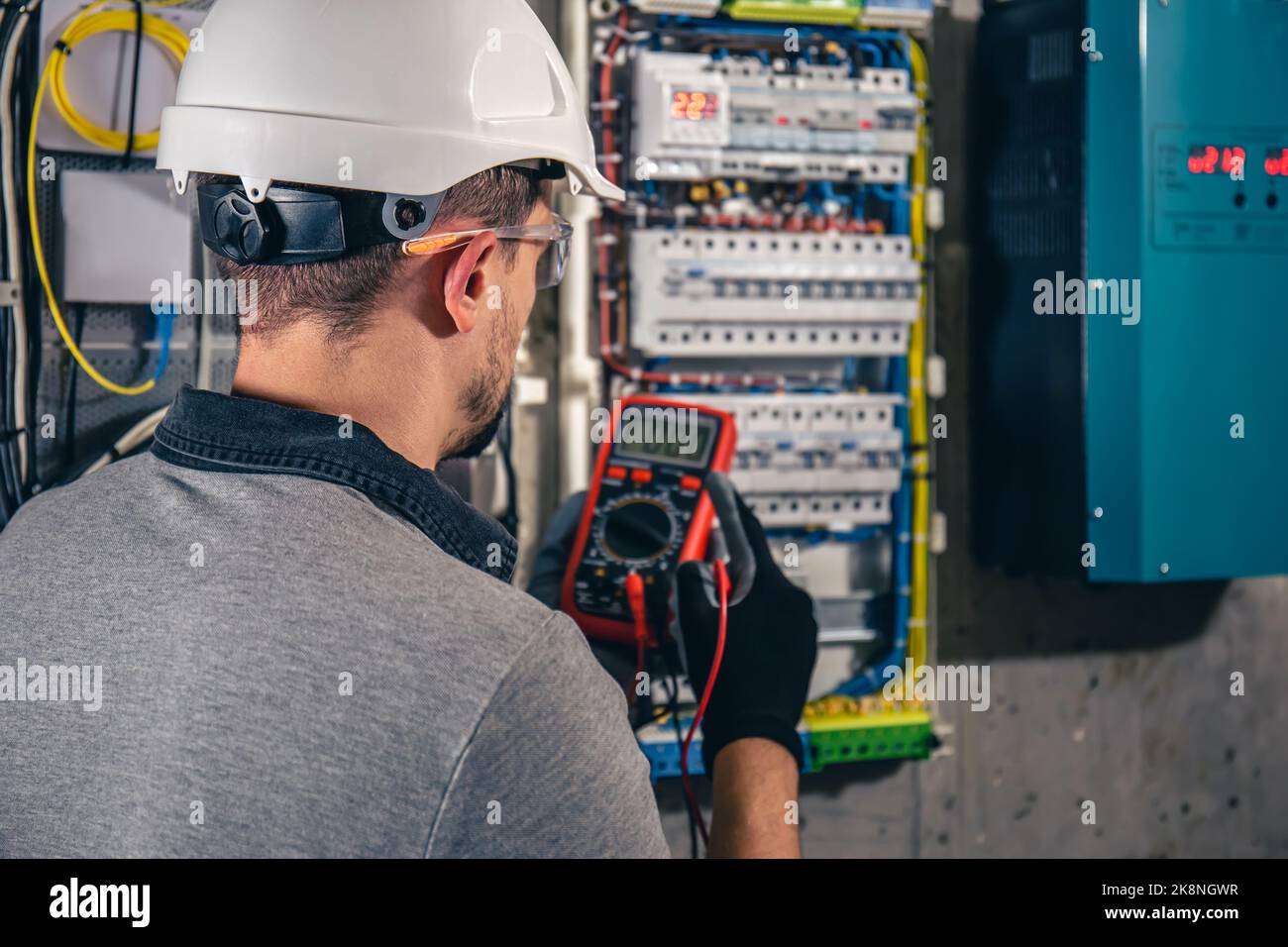 Man, an electrical technician working in a switchboard with fuses Stock ...