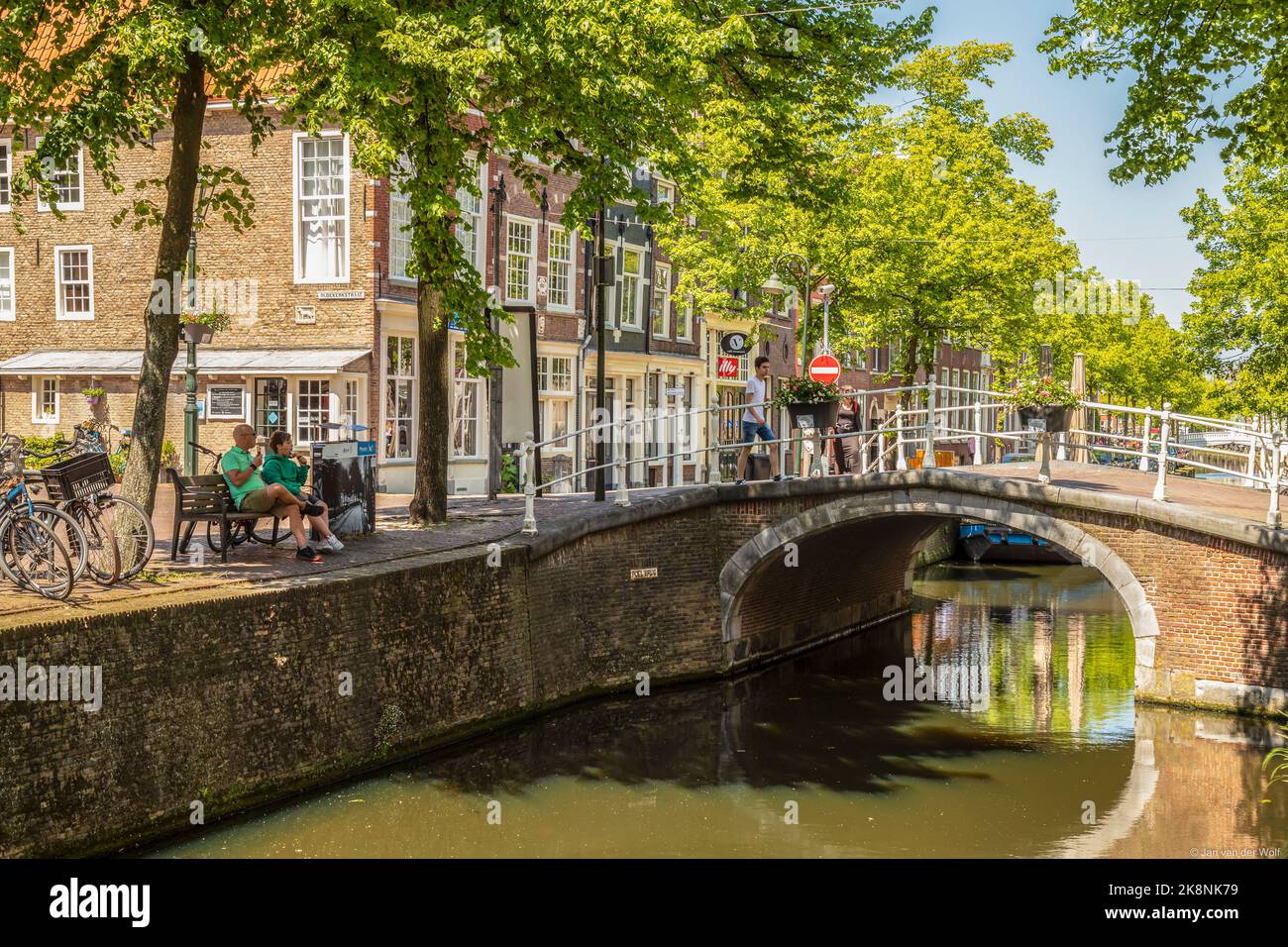 People on a bench along the canal in the historic center of the student ...