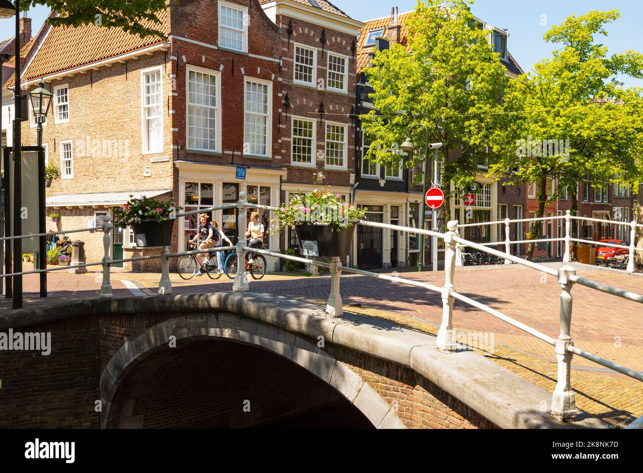 Young people cycle along the canal in the center of Delft Stock Photo ...