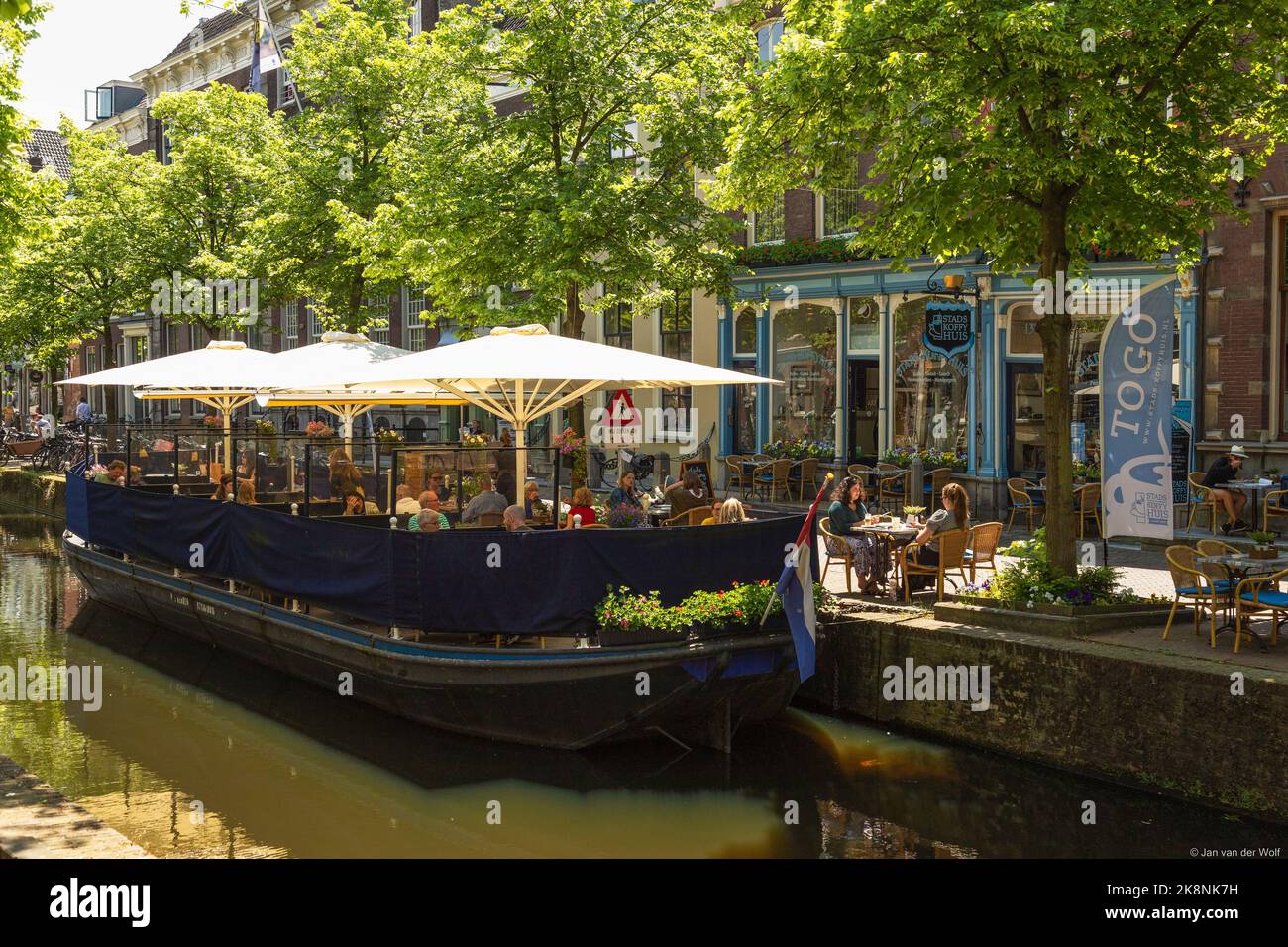 Locals and tourists on a terrace on a boat on the canal in the ...