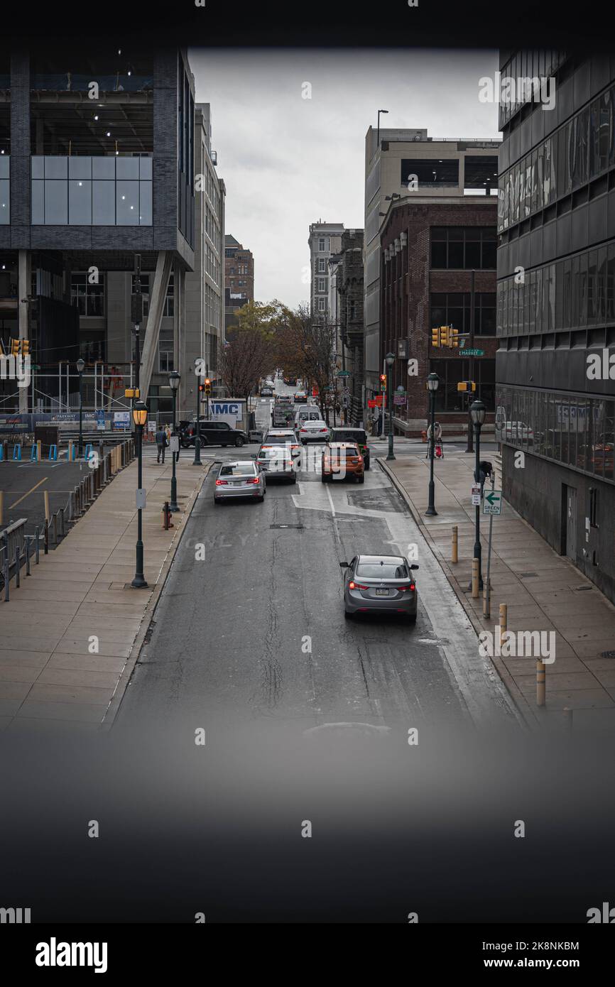 A Vertical shot of street with cars between modern buildings in ...