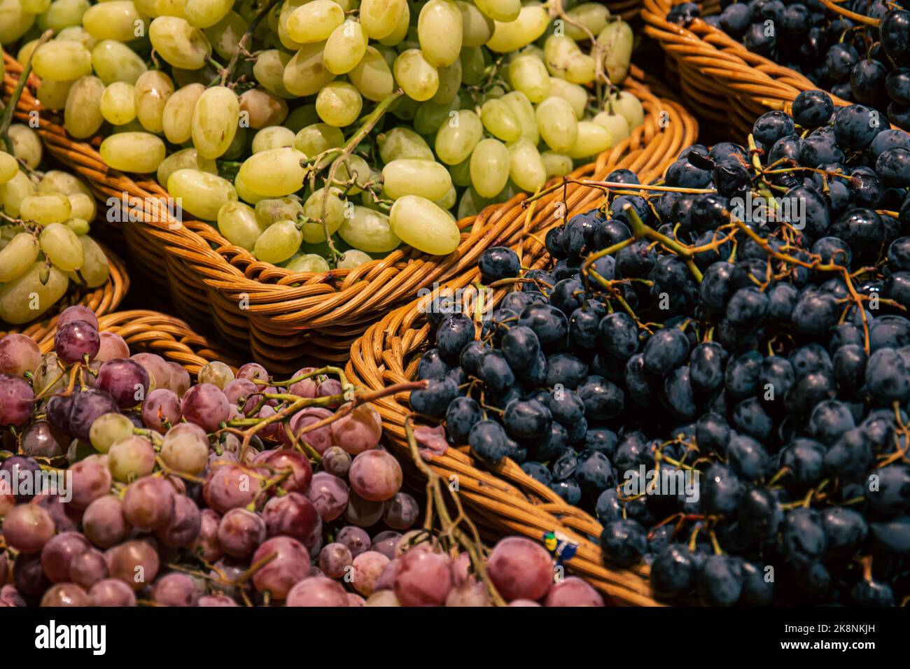 Baskets with different types of grapes on a supermarket showcase Stock ...