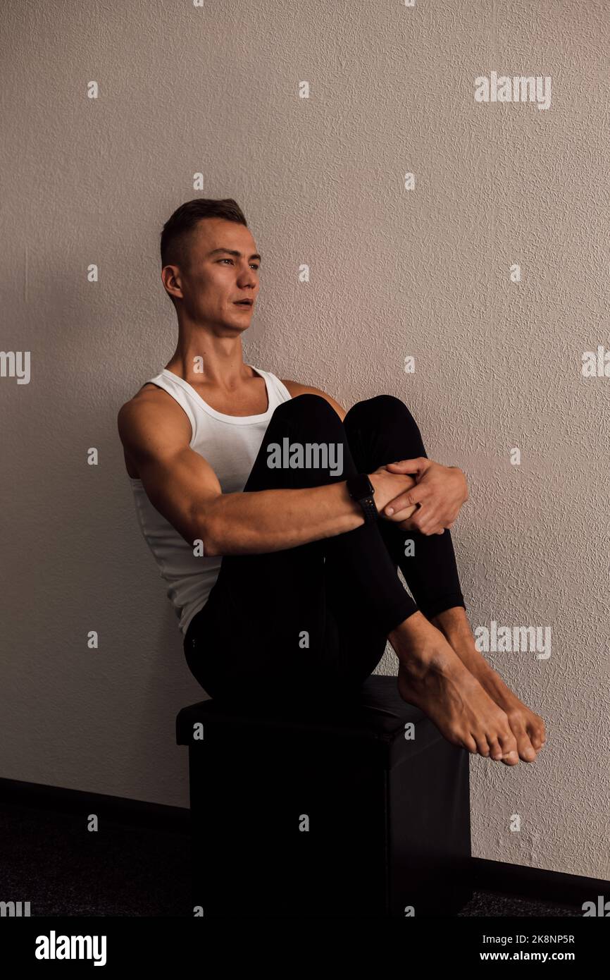 A young athlete sits on a fitball performing exercises. Sports Yoga ...