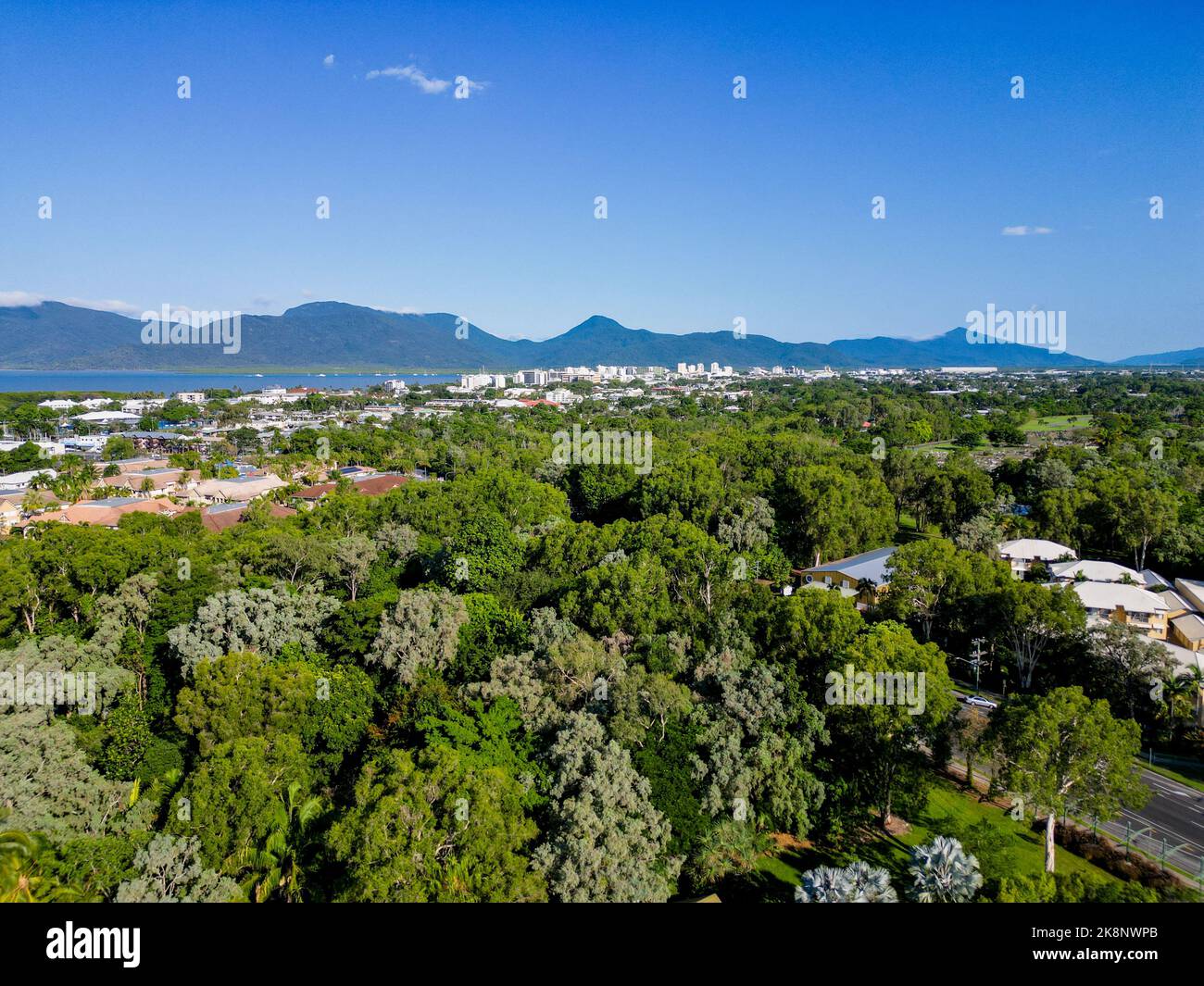 Aerial shot of the rainforest with houses and city in the backdrop ...