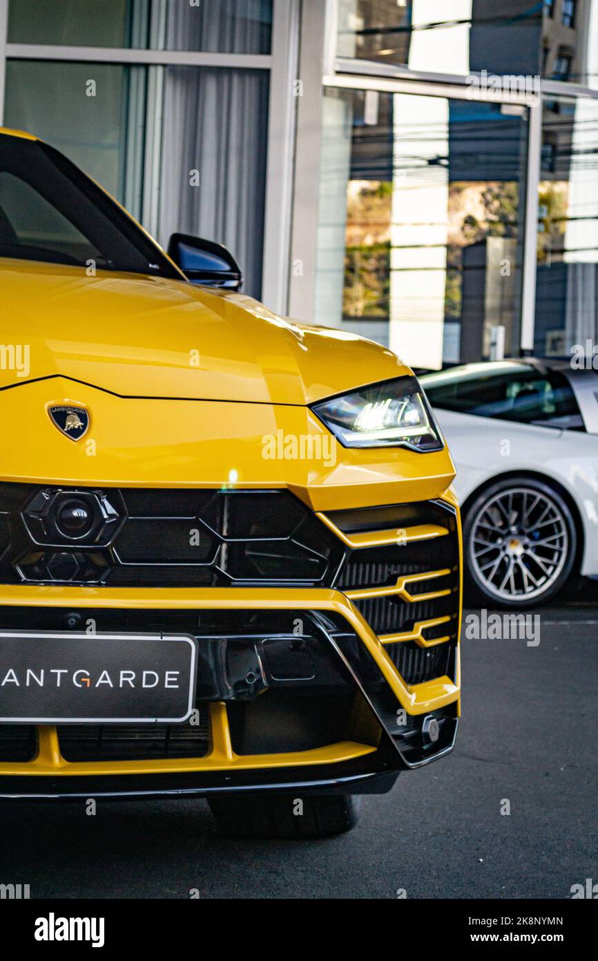 a vertical of Yellow Lamborghini Urus front view with headlights on ...