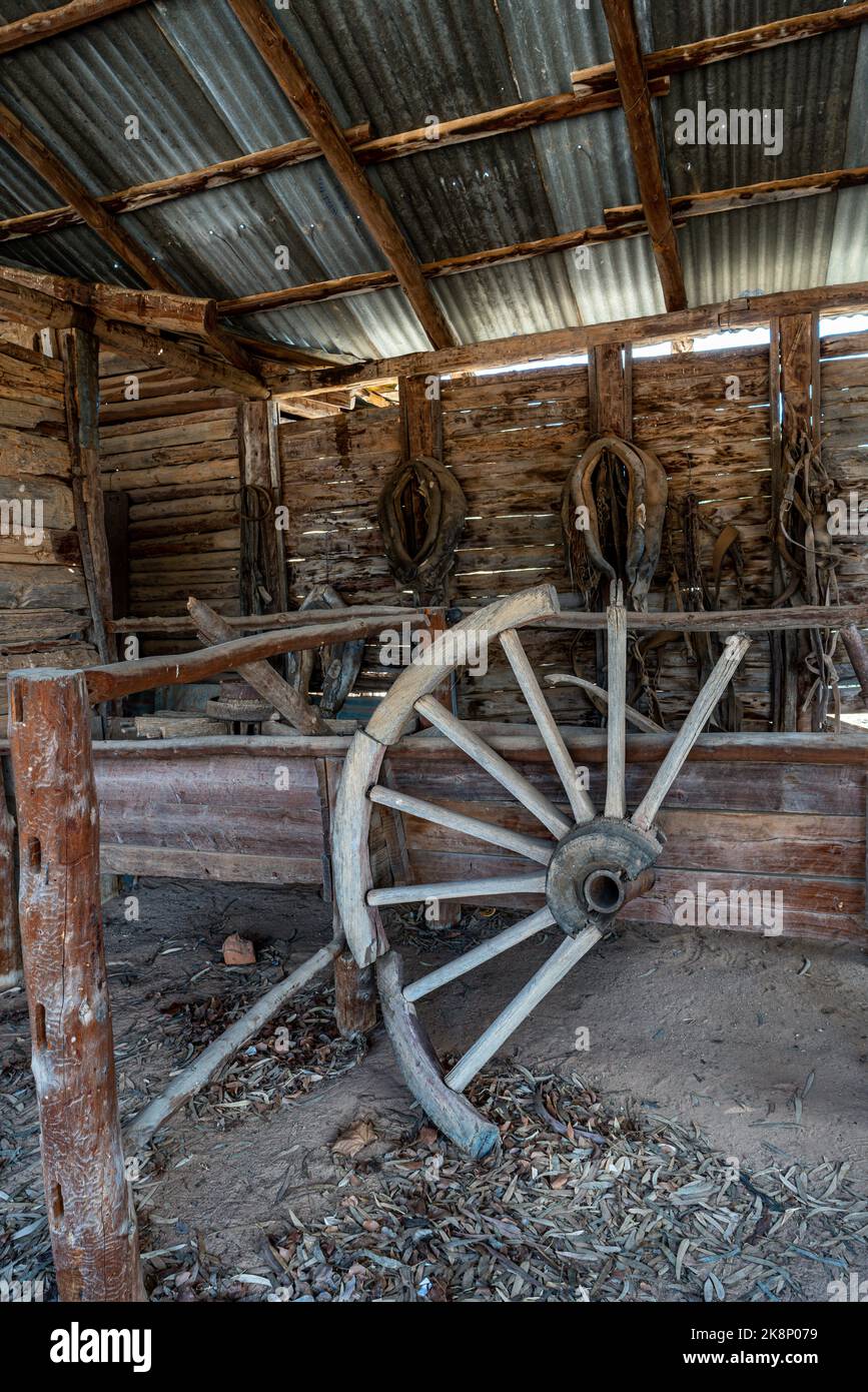 A vertical shot of a broken wooden wheel in an old stable, Mildura ...