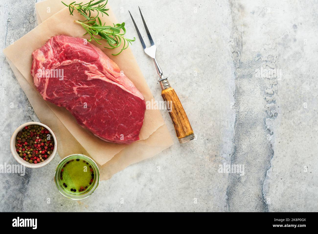 Raw beef steak. Fresh beef rib eye steak with fork rosemary, salt and ...