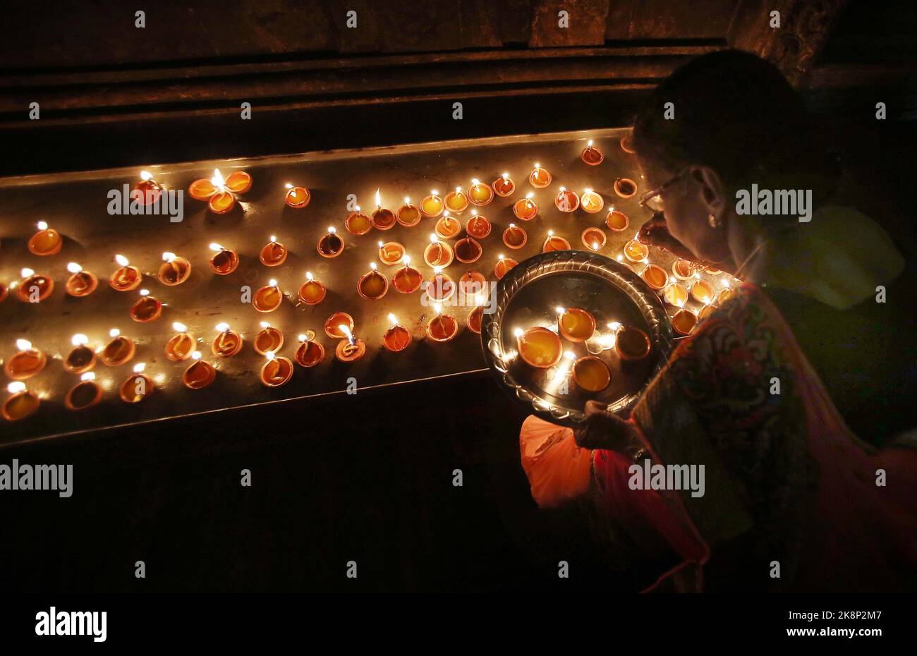 Colombo, Sri Lanka. 24th Oct, 2022. A Hindu devotee lays oil lamps to ...