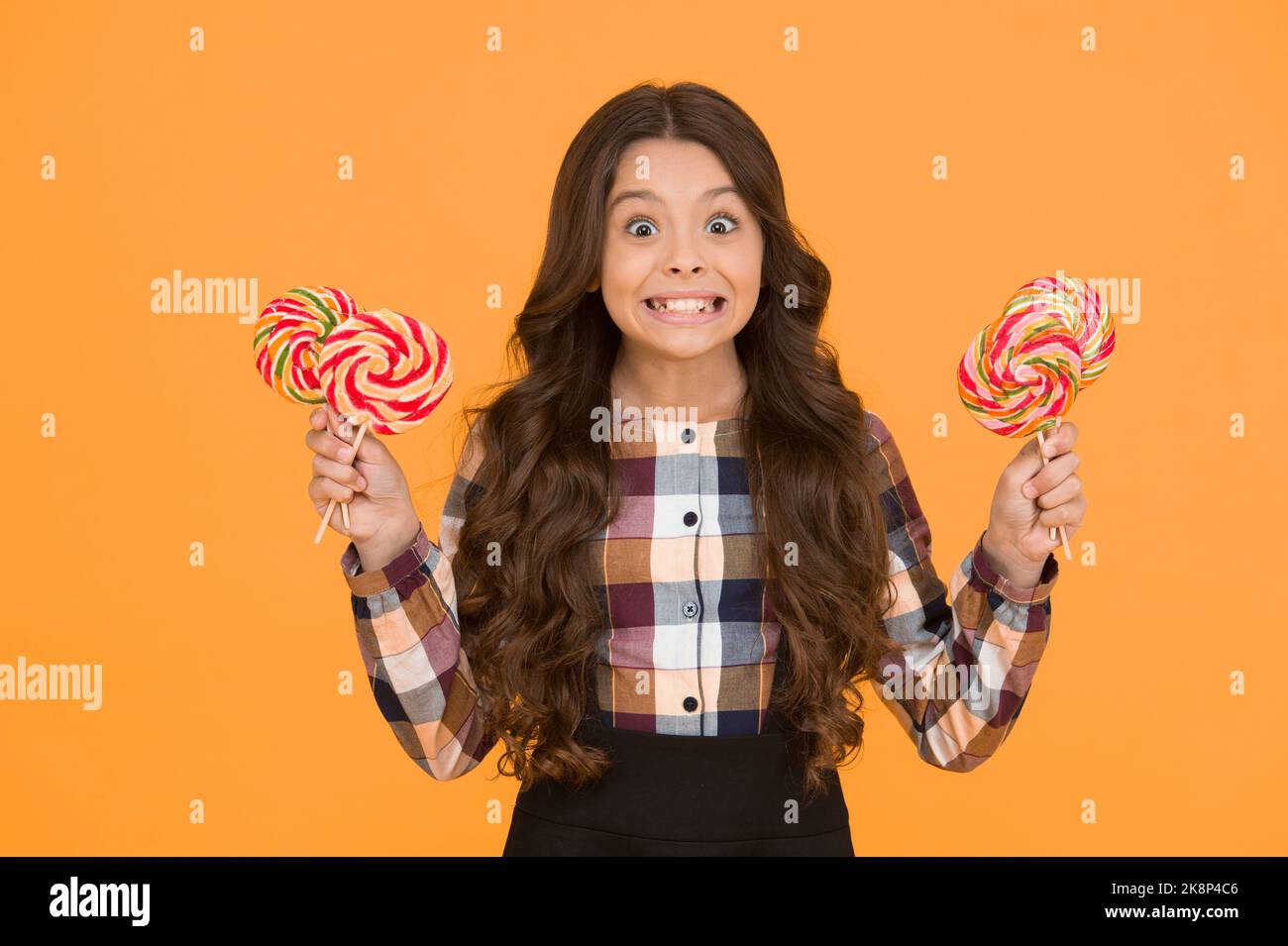 Always eat dessert first. Happy small schoolchild hold candy dessert on ...