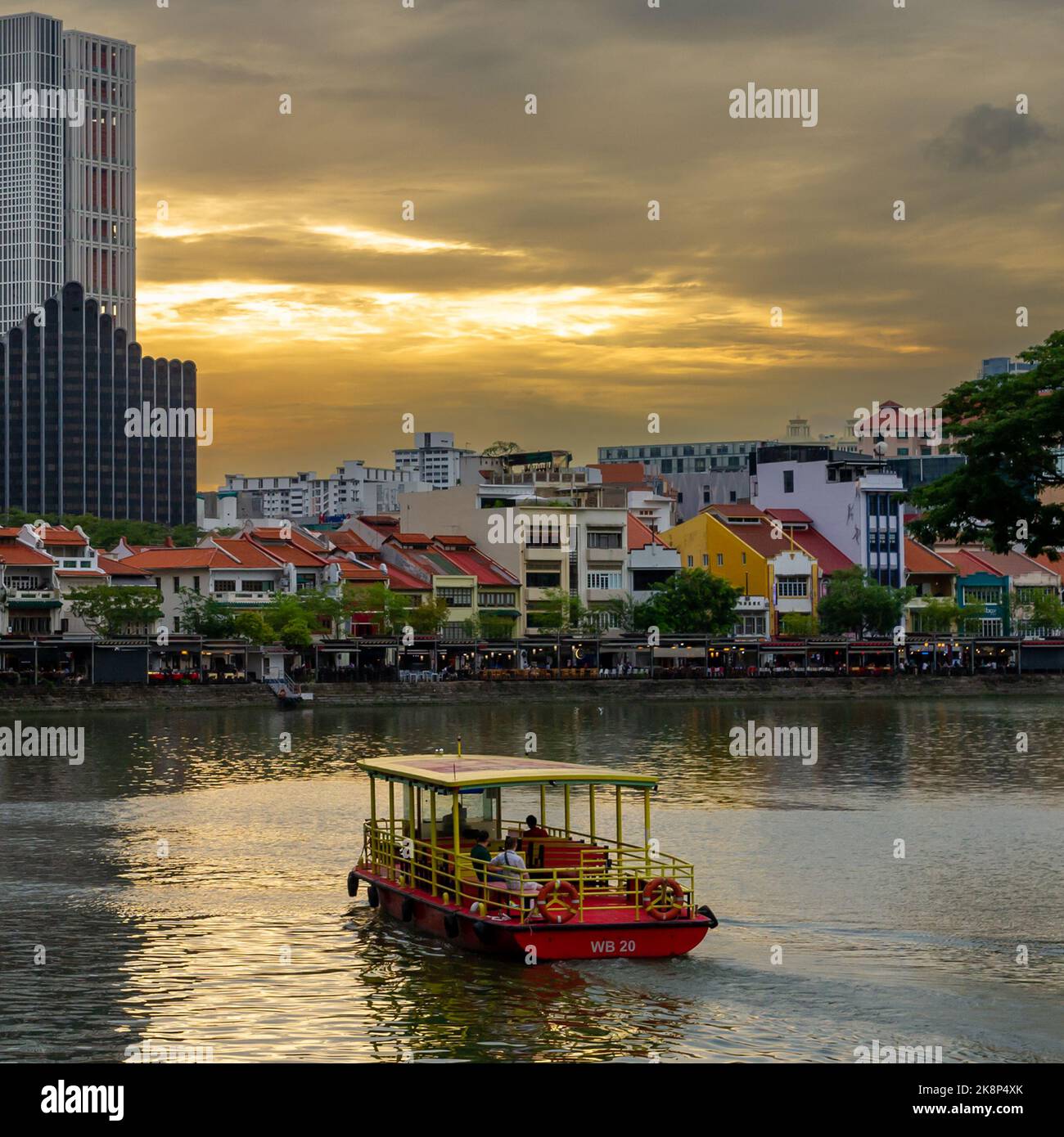 Tourist Boats passing by Boat Quay along the Singapore River at sunset ...