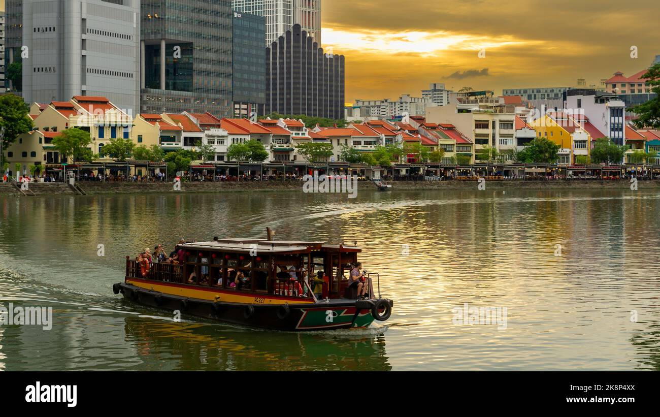 Tourist Boats passing by Boat Quay along the Singapore River at sunset ...