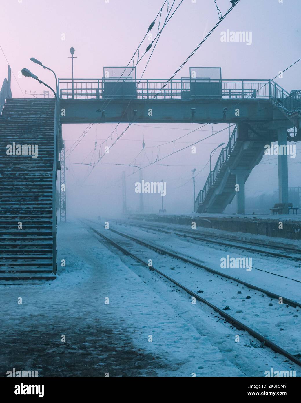 early morning railways station platform at snowy cold winter time ...