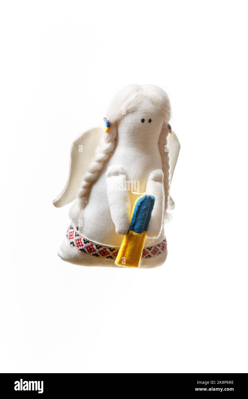 White fabric soft angel toy with wings holding a candle with a color of ...