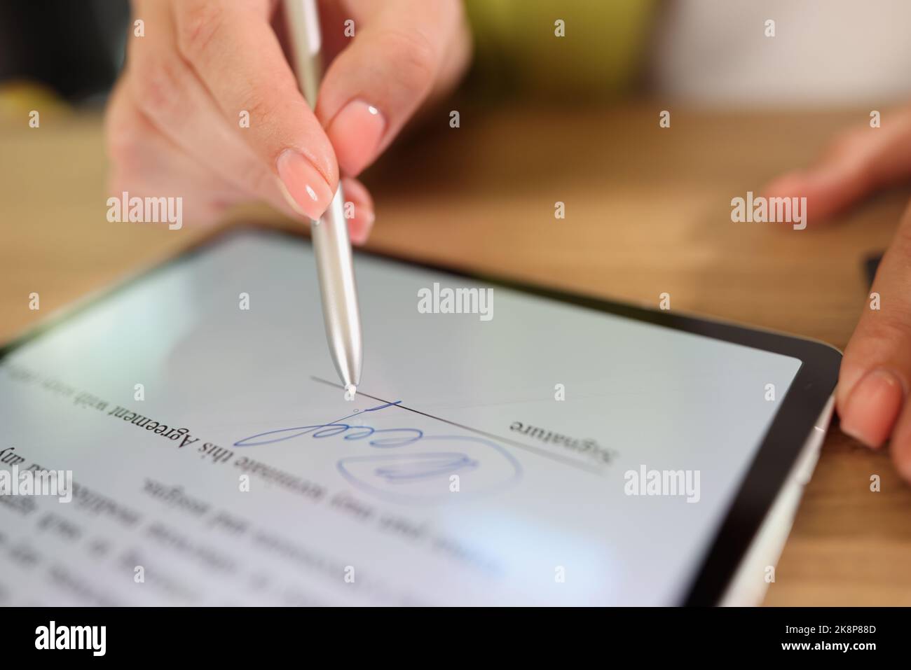 Female hand signing e-document on tablet with stylus Stock Photo - Alamy