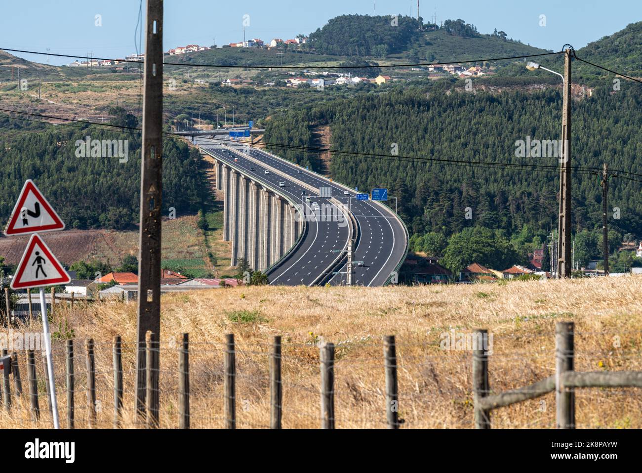 An aerial view of road with driving cars surrounded by dense trees in ...
