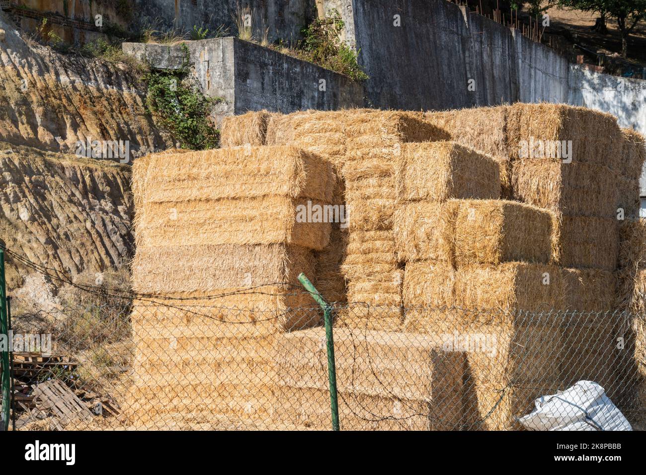 An aerial view of various hay straw bales stored behind wire fences ...