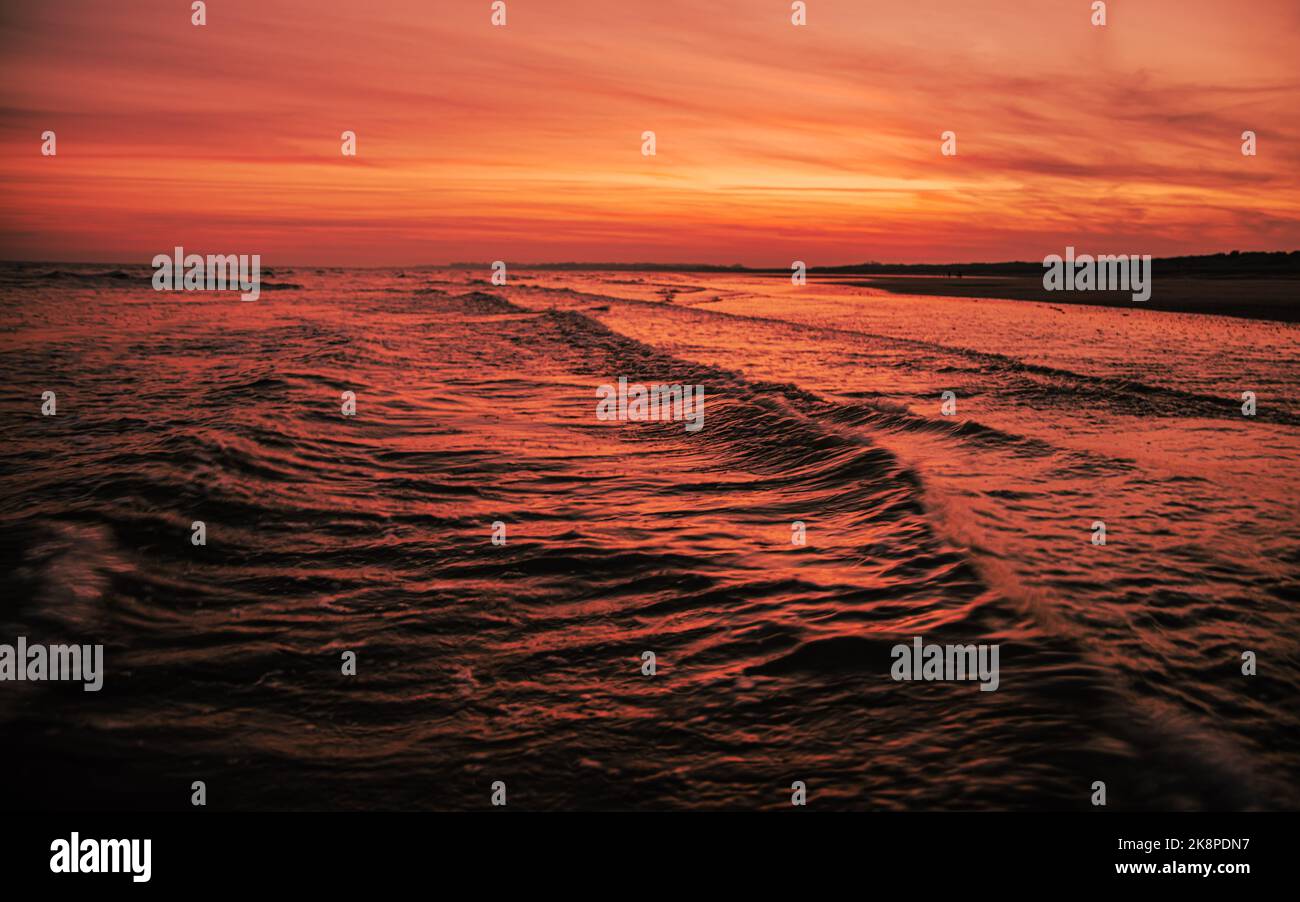 An aerial view of sea waves breaking beach during sunset Stock Photo ...