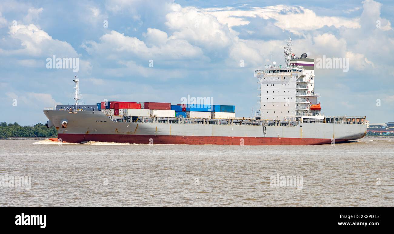 A container ship loaded with containers sails alongside the shore Stock ...