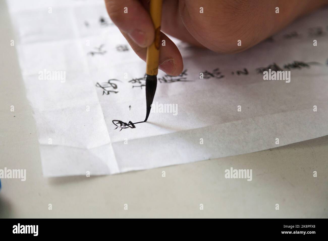 Chinese writing handwritten in vertical lines on a sheet of folded ...